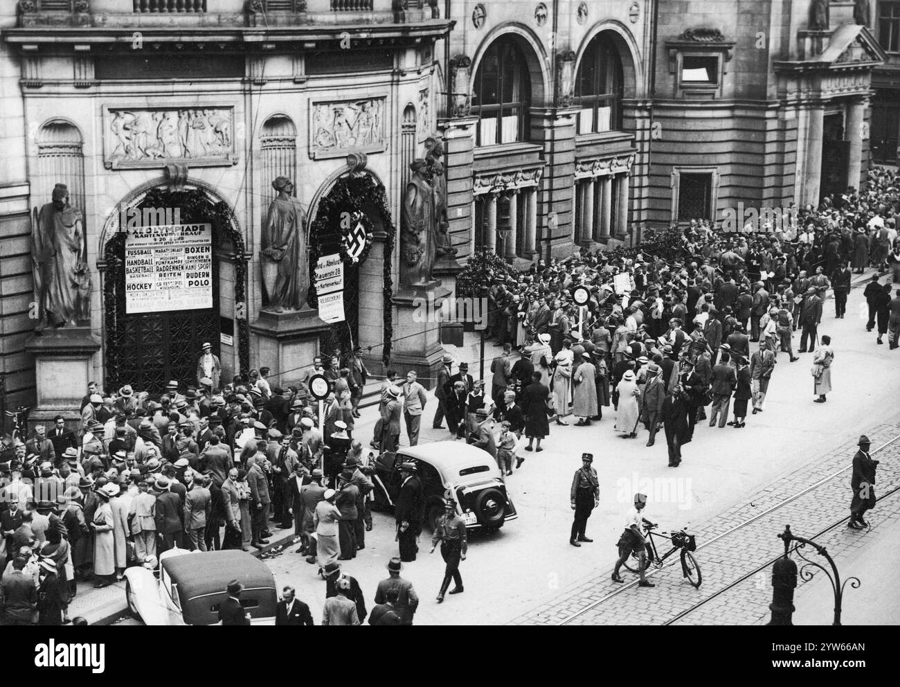 Ticket sales for the Berlin Olympics begin. Crowd in front of the sales point. Tram tracks, cars ...