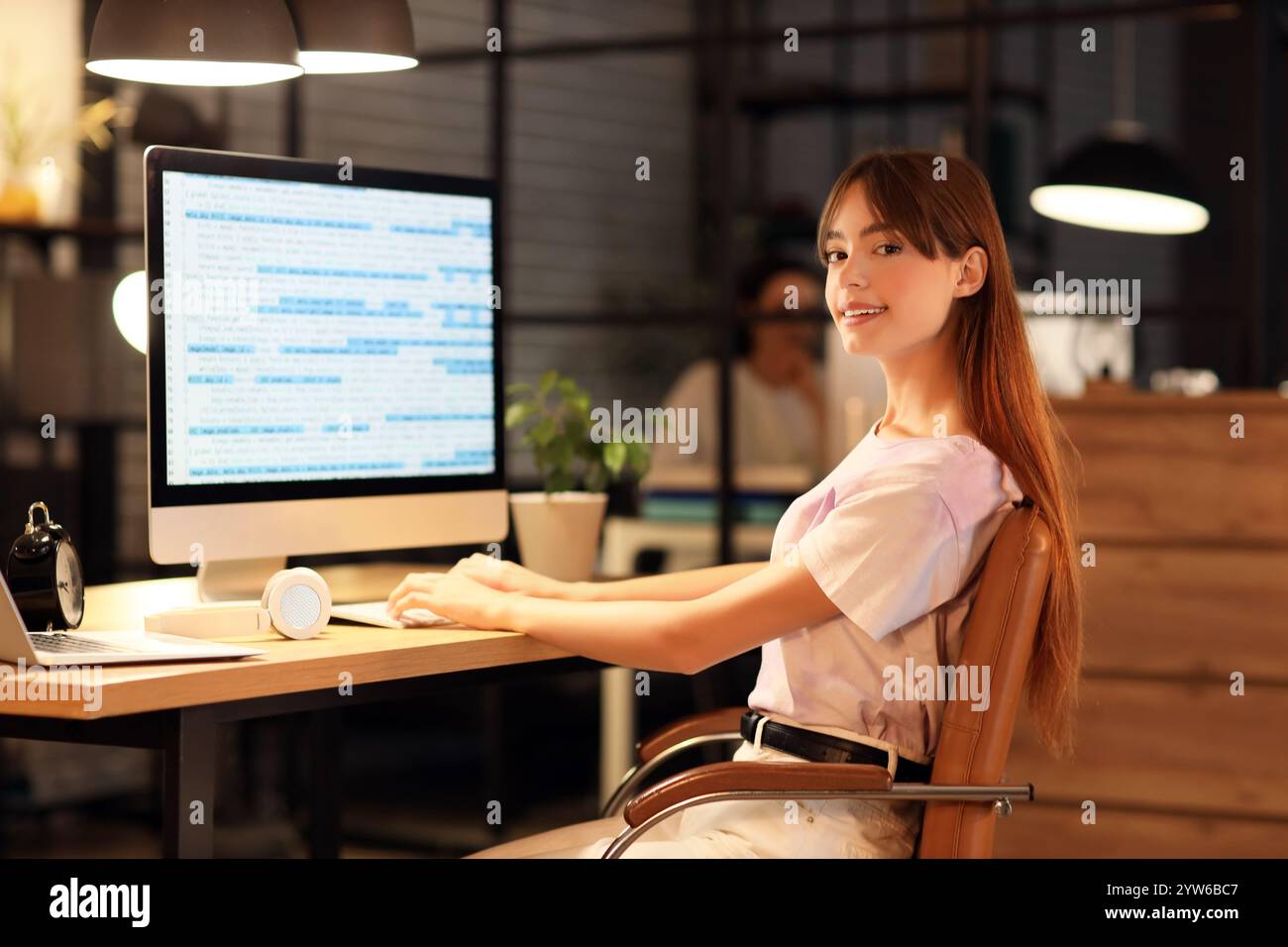 Female programmer working with computer in office at night Stock Photo ...