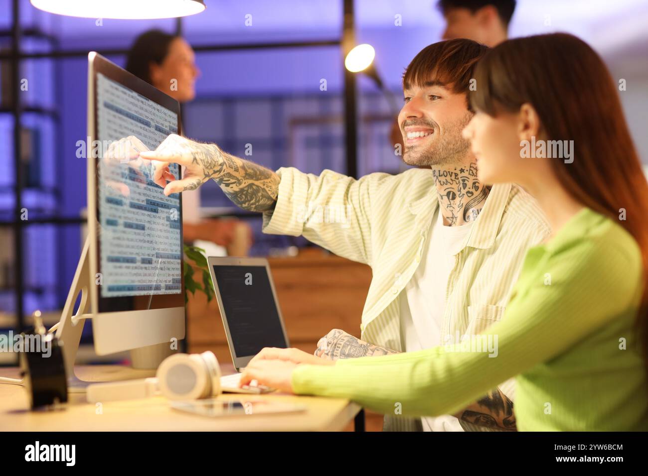 Young programmers working with computer in office at night Stock Photo ...