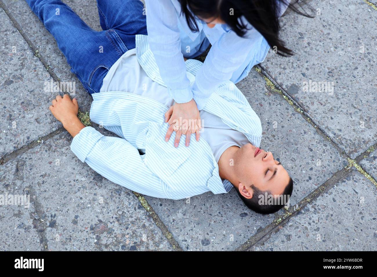 Young woman doing CPR to unconscious husband having heart attack on ...