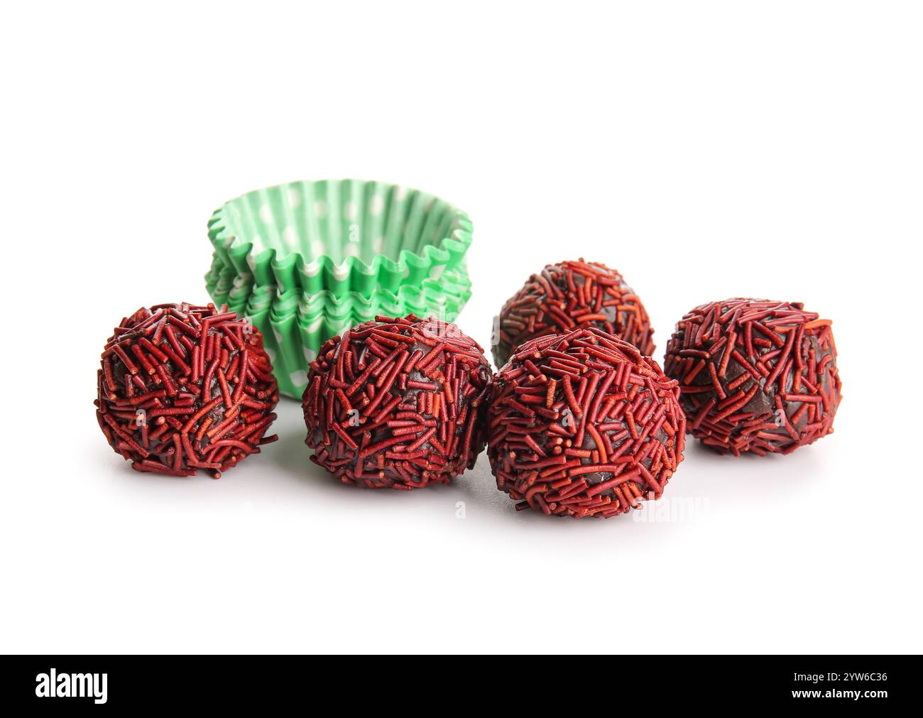 Delicious chocolate truffles and green paper cups on white background ...