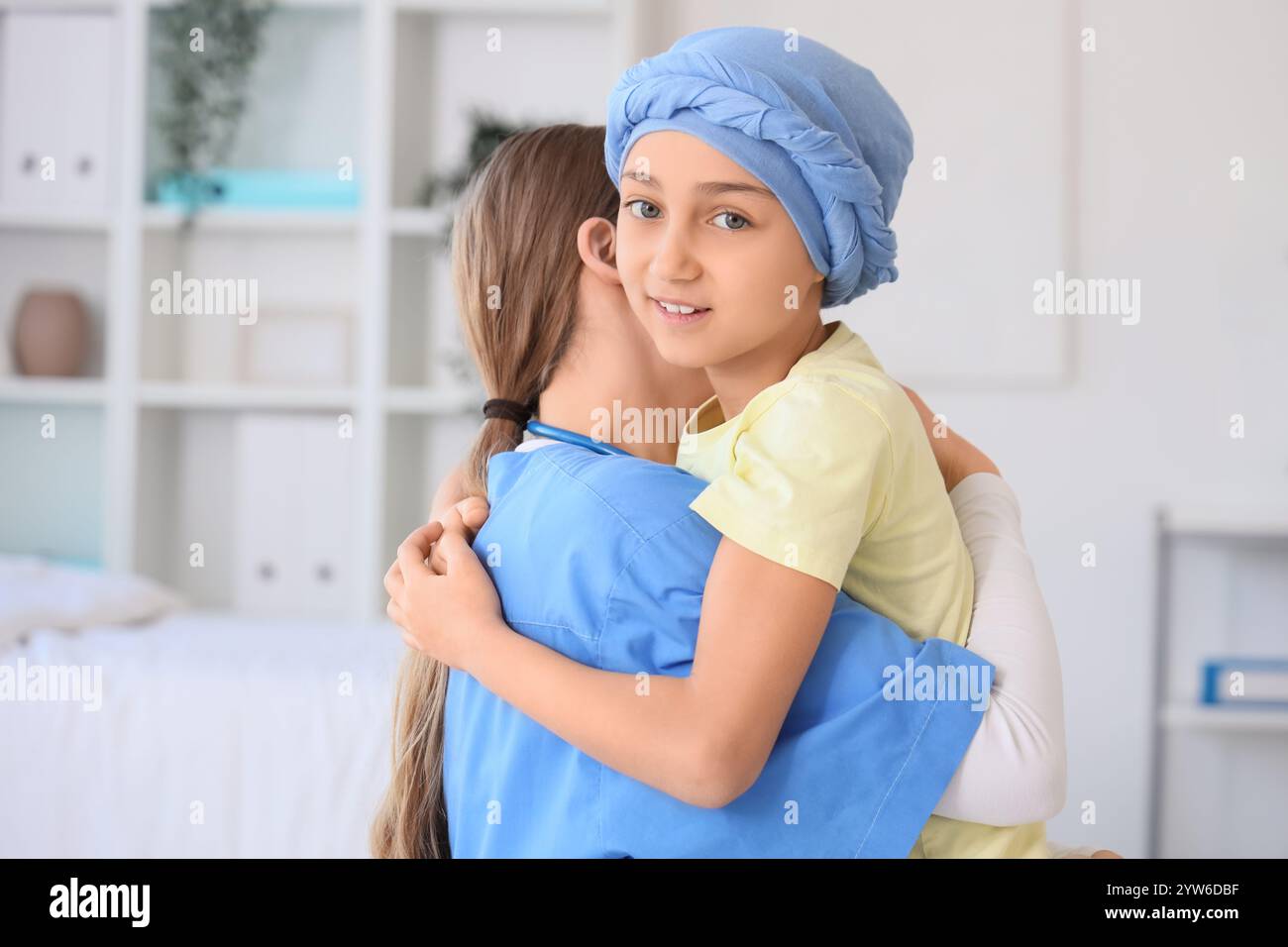 Little girl after chemotherapy hugging nurse at hospital. Childhood ...