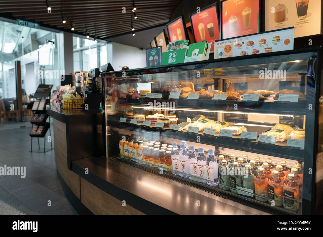 SENAI, MALAYSIA - NOVEMBER 22, 2023: display case with snacks, desserts ...