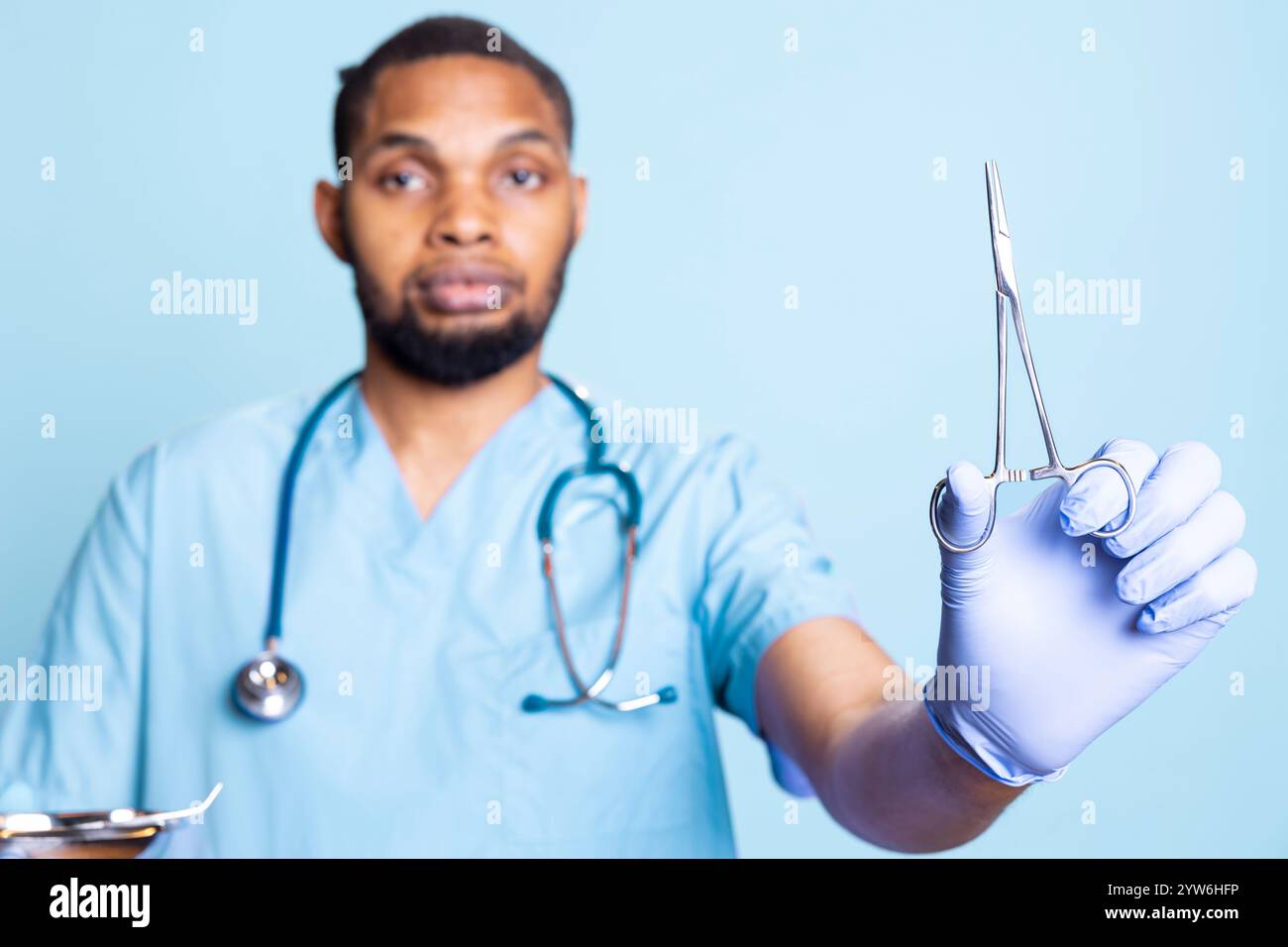 Professional nurse in scrubs holding medical tools used for incision ...
