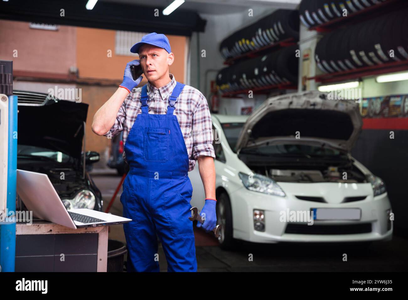 Car mechanic calls on smartphone to client Stock Photo - Alamy