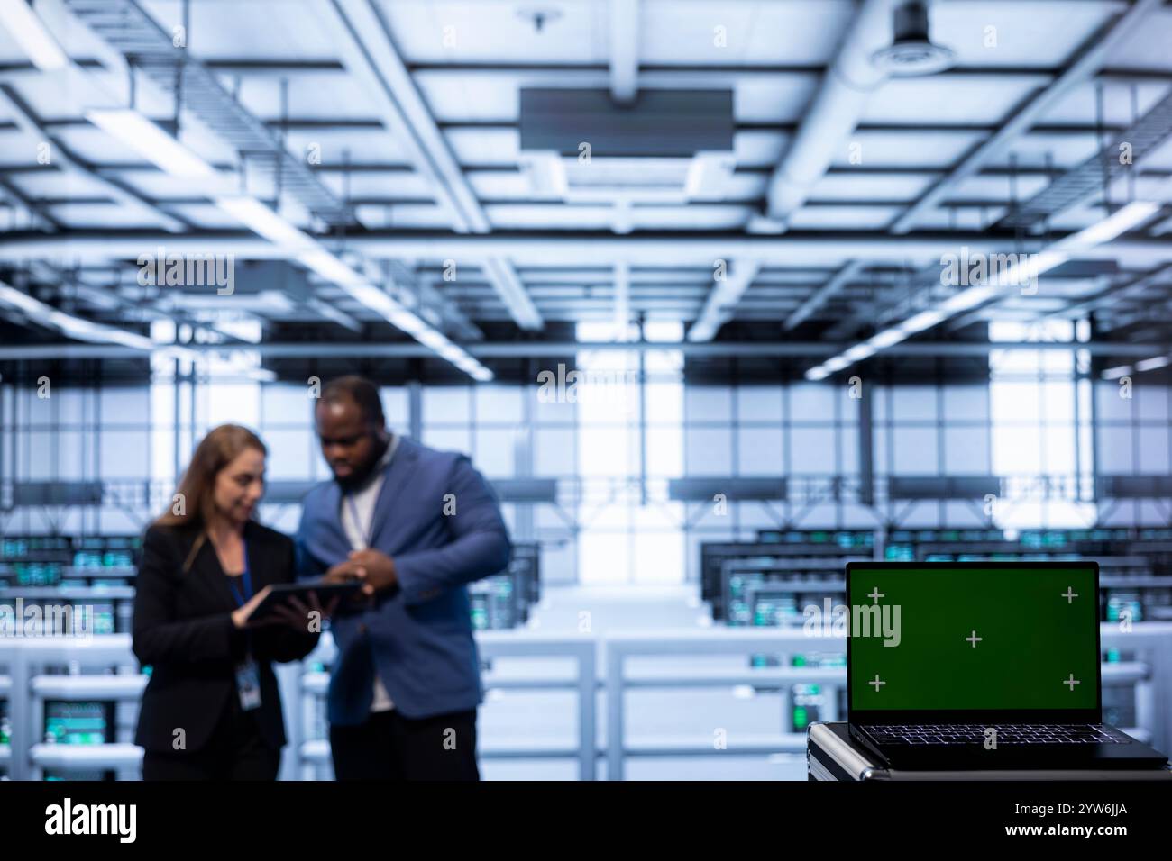 Focus on isolated screen laptop device used by coworkers in data center blurry background. Close ...