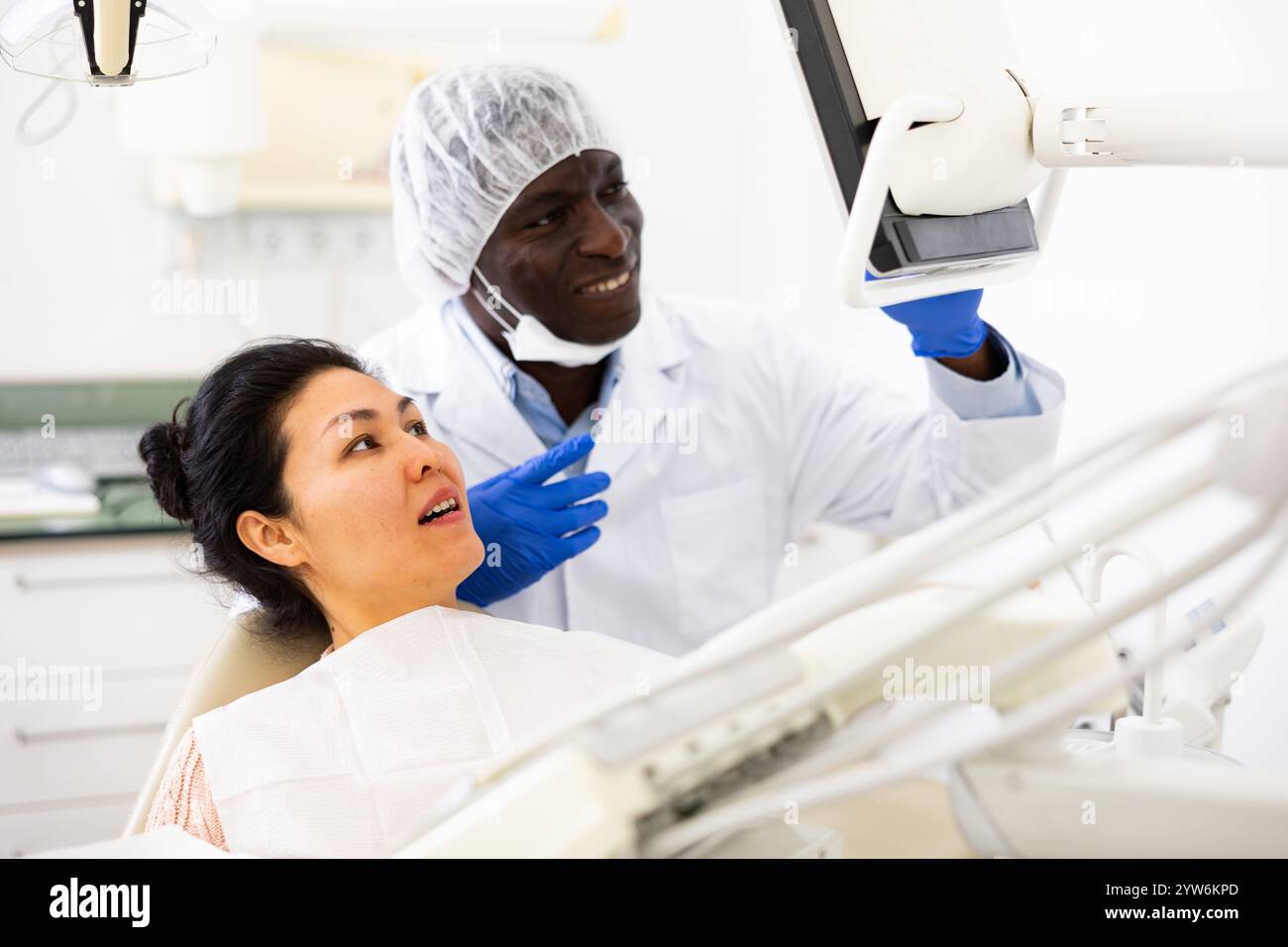 Man dentist pointing at display to show information to patient Stock ...