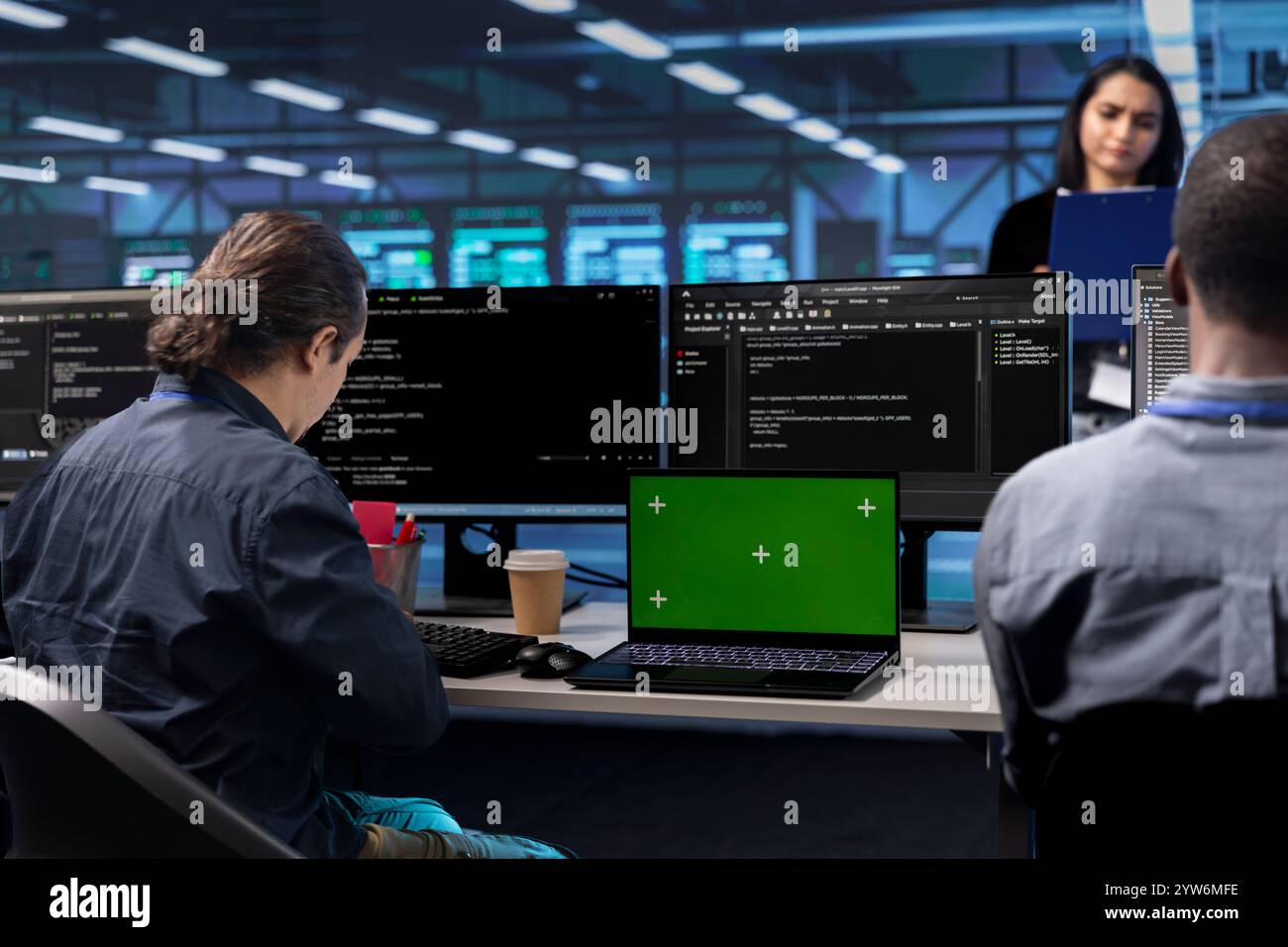 Multiracial people in data center updating systems with green screen device, protecting tech ...