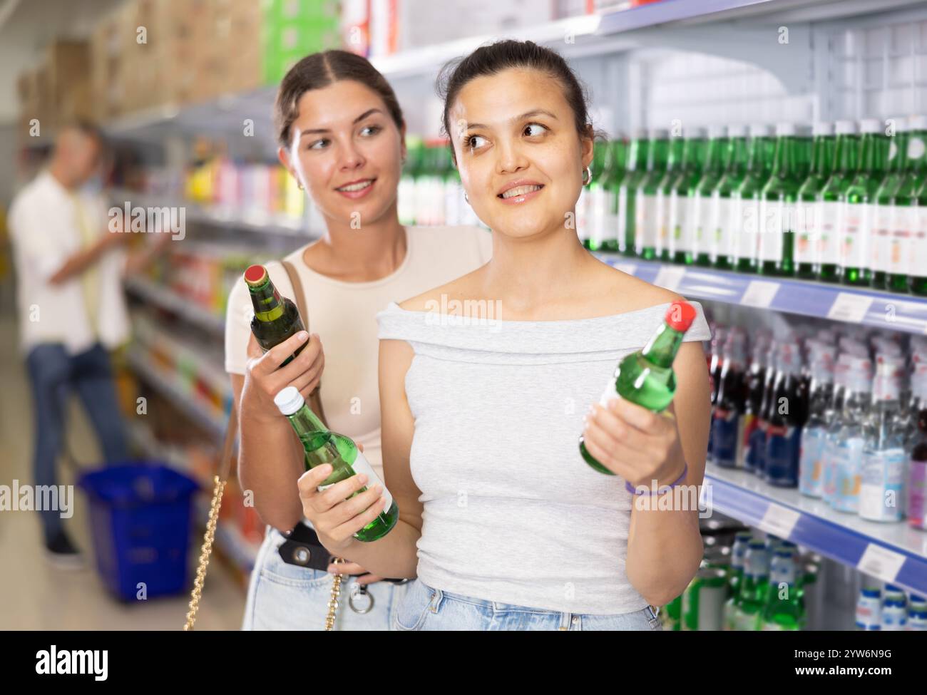 Two happy girlfriends choose sweet lemonade in Chinese supermarket ...