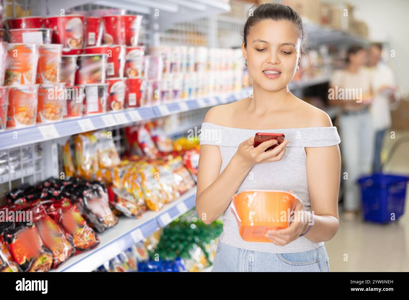 Asian woman scanning QR code on bowl of instant noodles in store Stock ...
