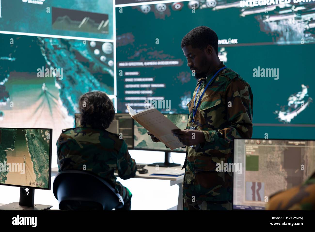 Military control tower personnel monitoring air traffic activity in command post, examining data ...