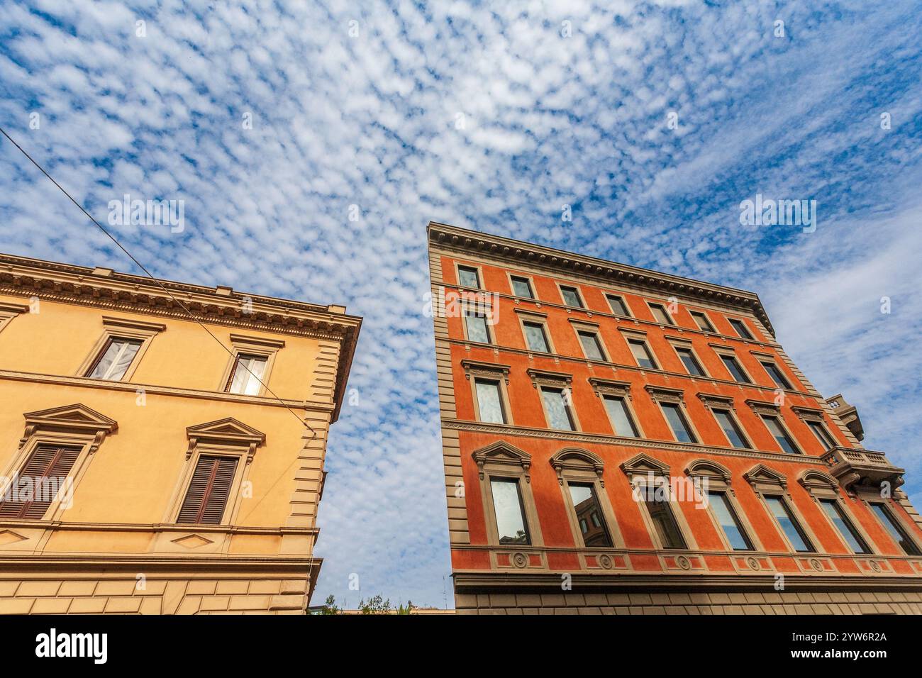 Classic Roman buildings with vibrant facades under a dramatic cloud ...
