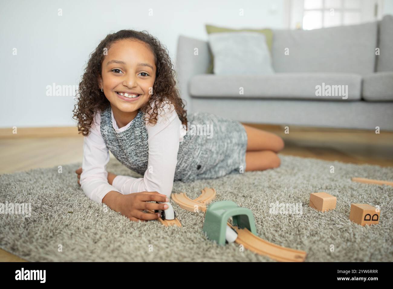 Happy girl playing with wooden train set in cozy living room Stock ...