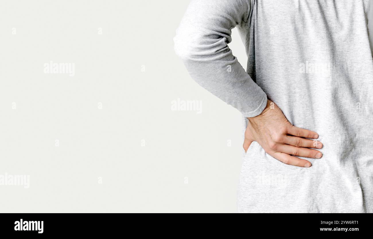 Muscle spasm, rheumatism. Man holds to his back with hand Stock Photo ...