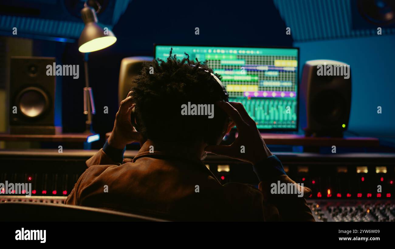 African american music producer recording tracks and editing them in ...