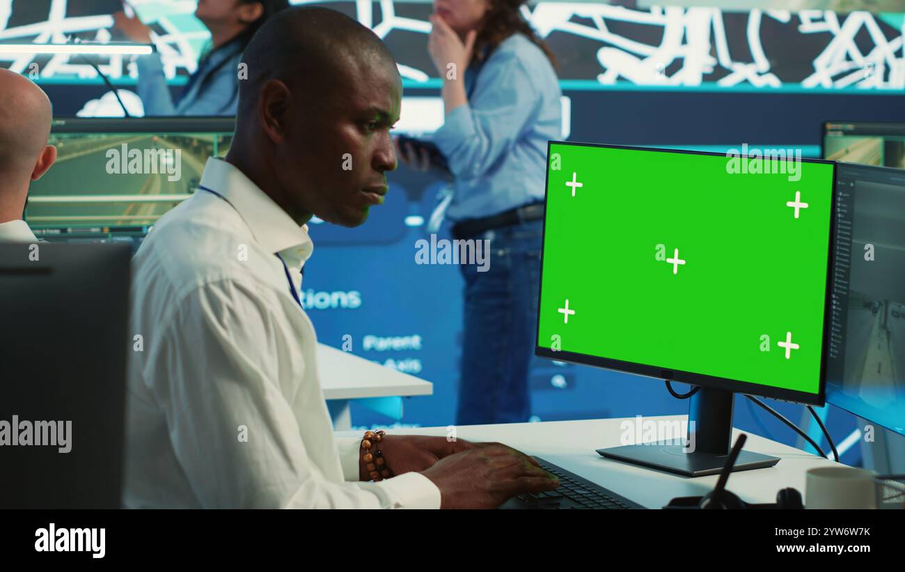 African american employee using greenscreen display and CCTV real time ...