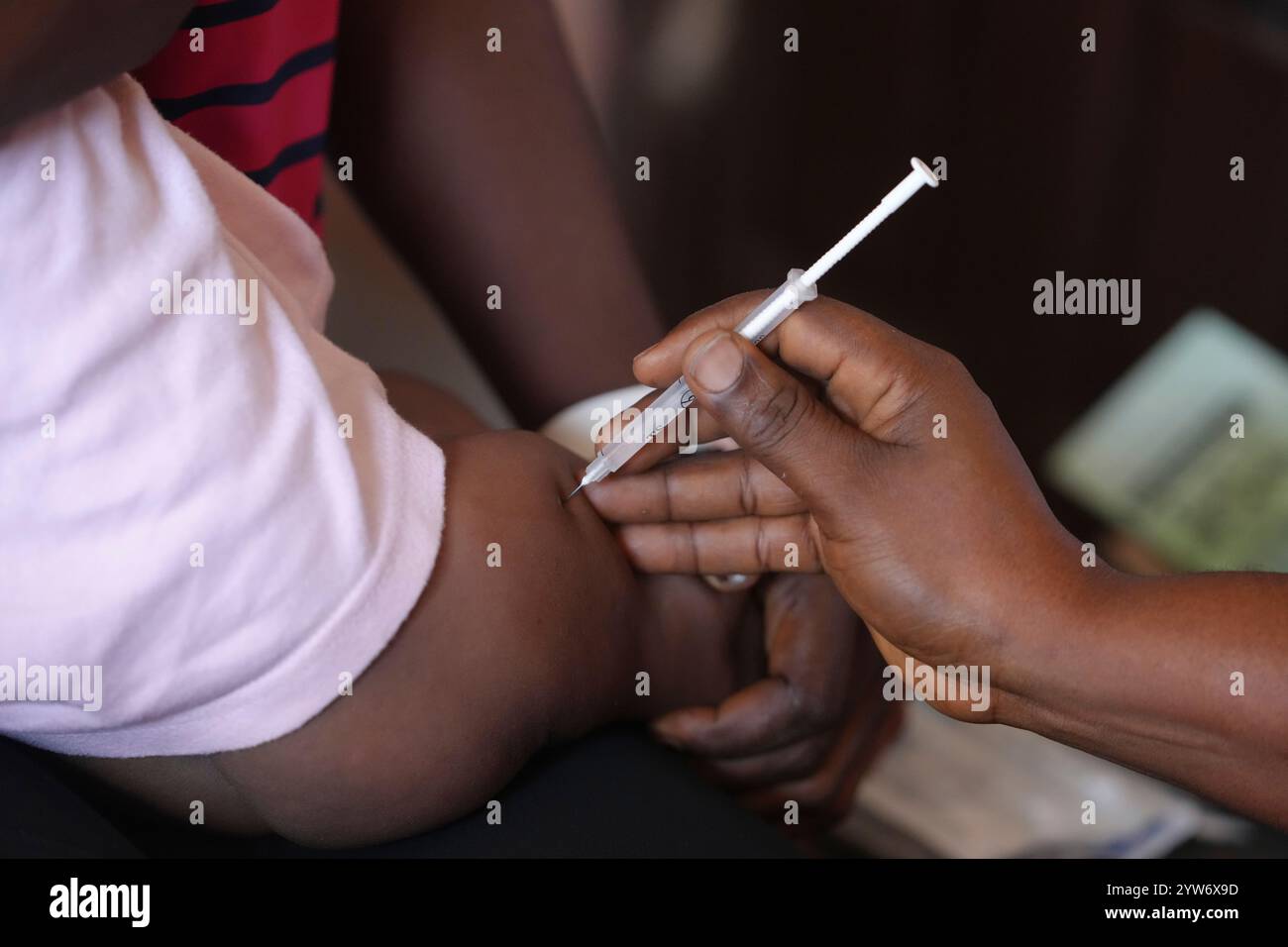 A health worker administer the malaria vaccine R21/Matrix-M to a child ...