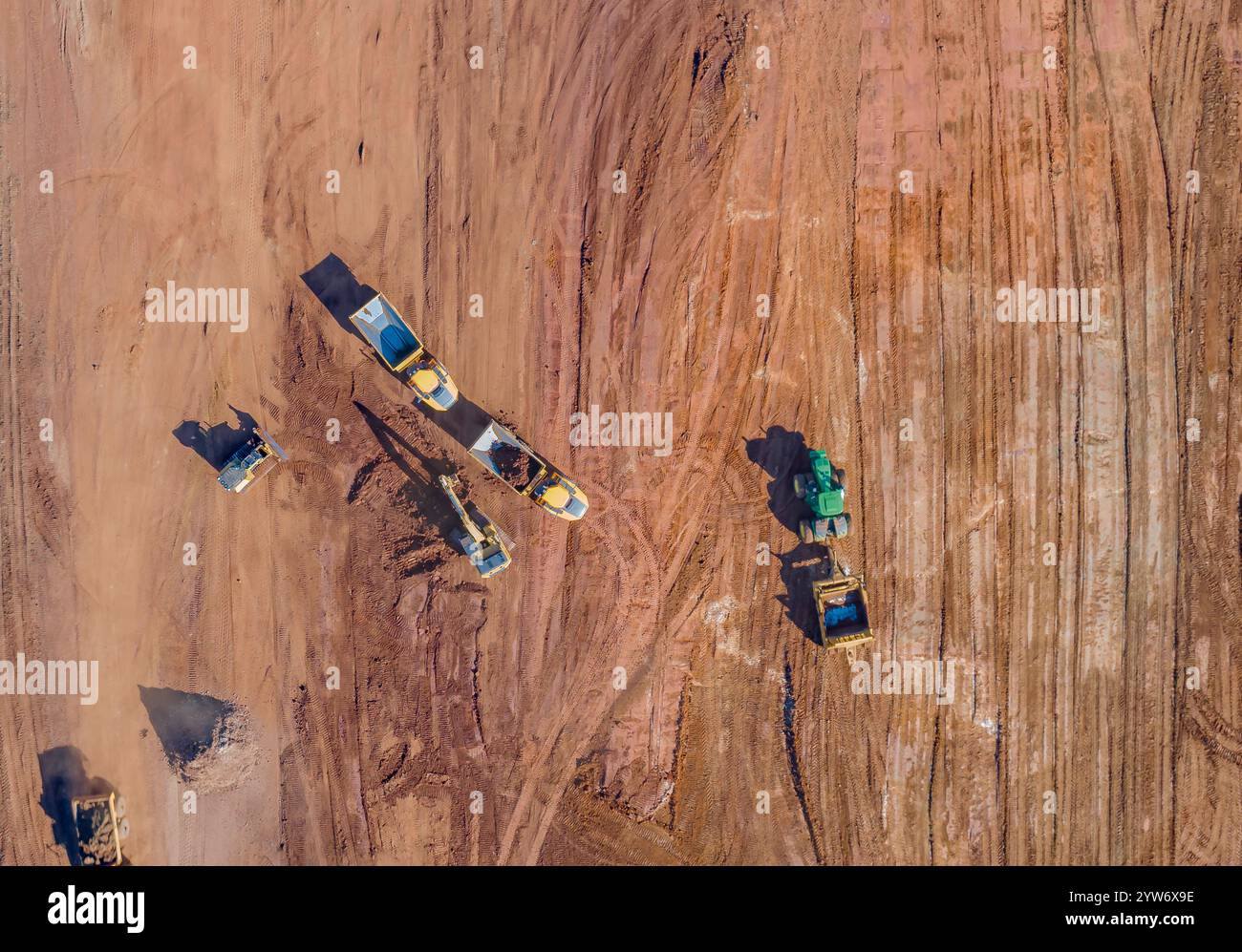 An aerial view of a bustling construction site shows bulldozers, trucks ...