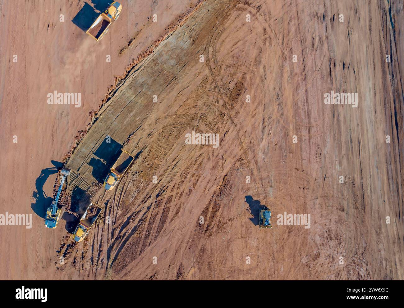 An aerial view of a bustling construction site shows bulldozers, trucks ...