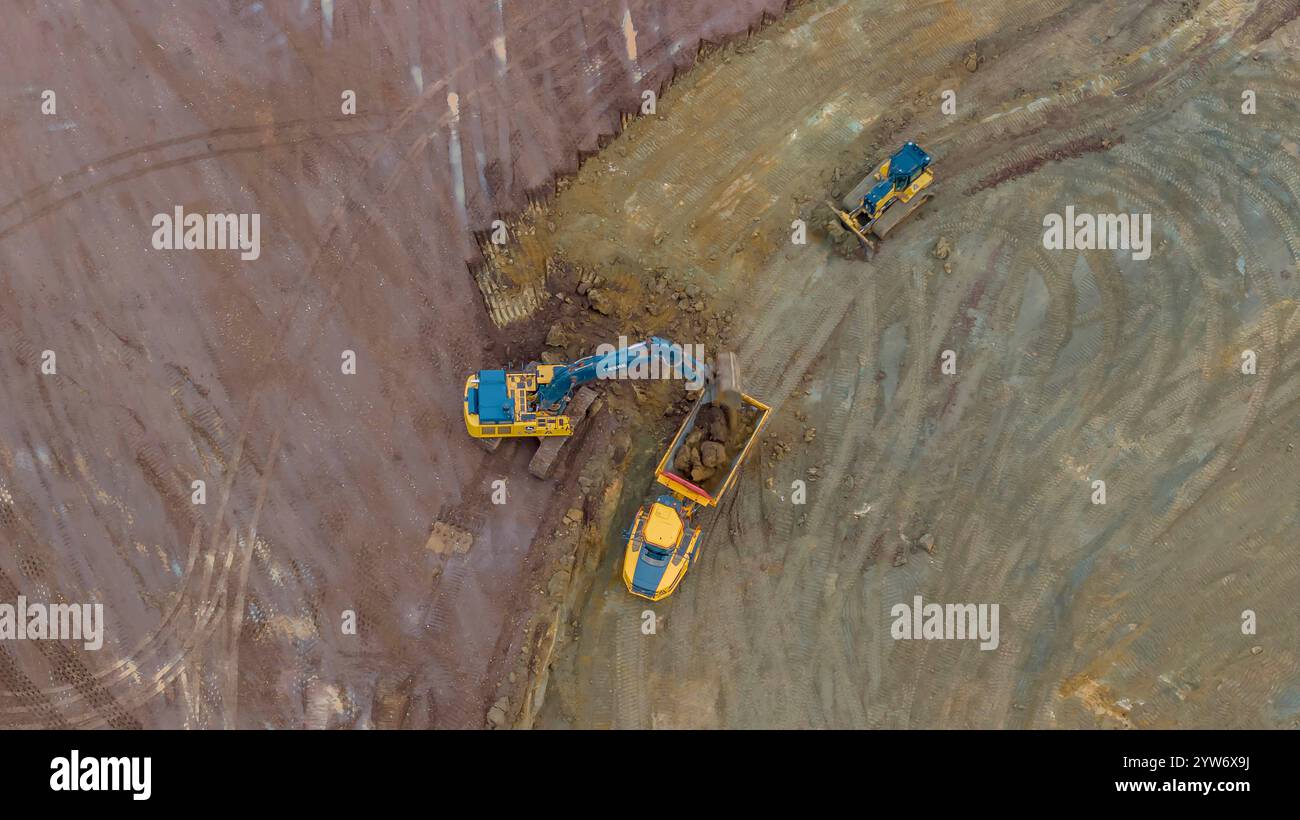 An aerial view of a bustling construction site shows bulldozers, trucks ...