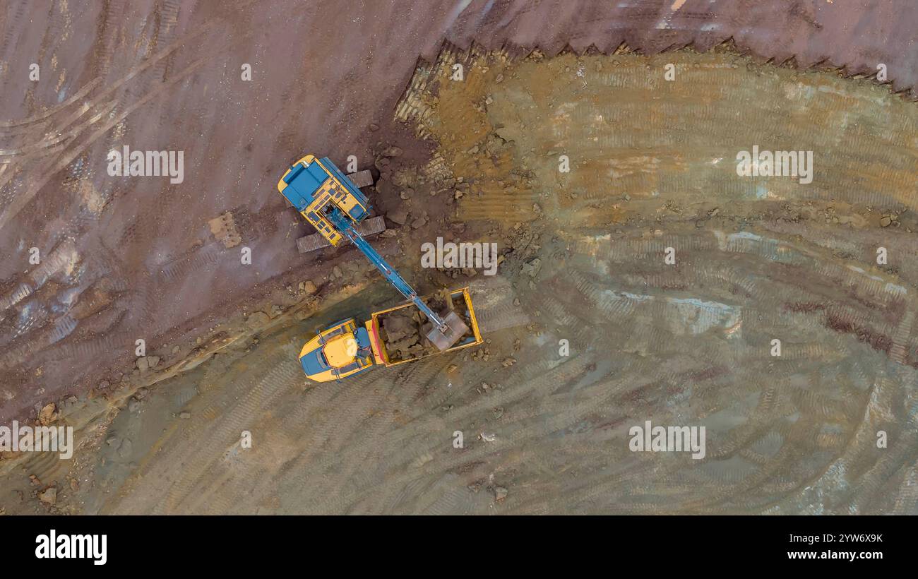 An aerial view of a bustling construction site shows bulldozers, trucks ...