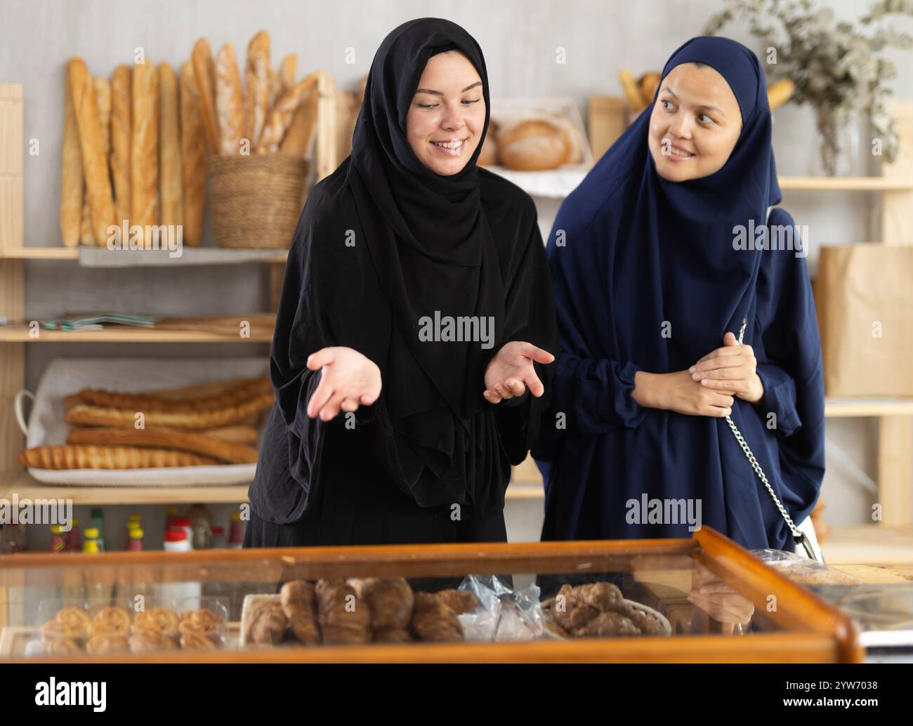 Two girls in traditional Muslim clothing chat and choose delicious ...