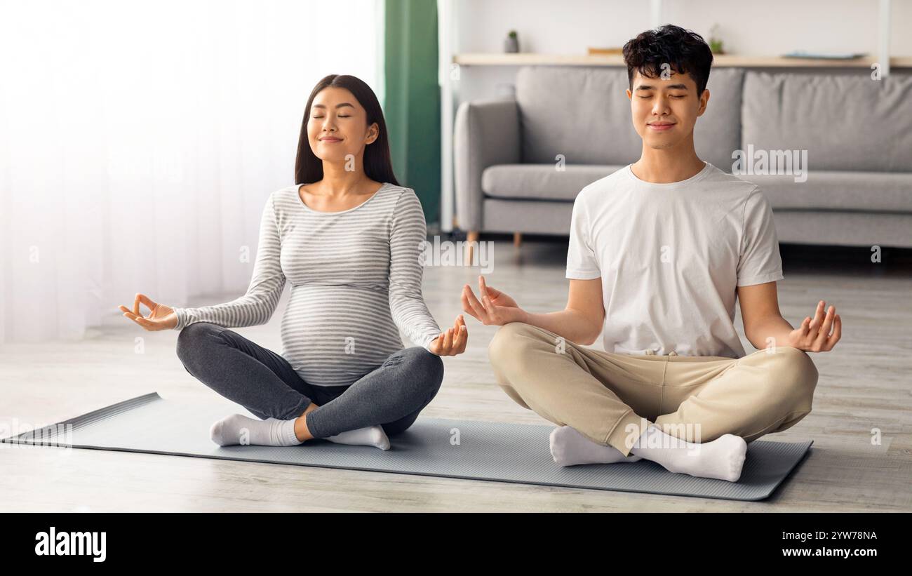 Relaxed expecting asian couple having yoga practice together Stock ...