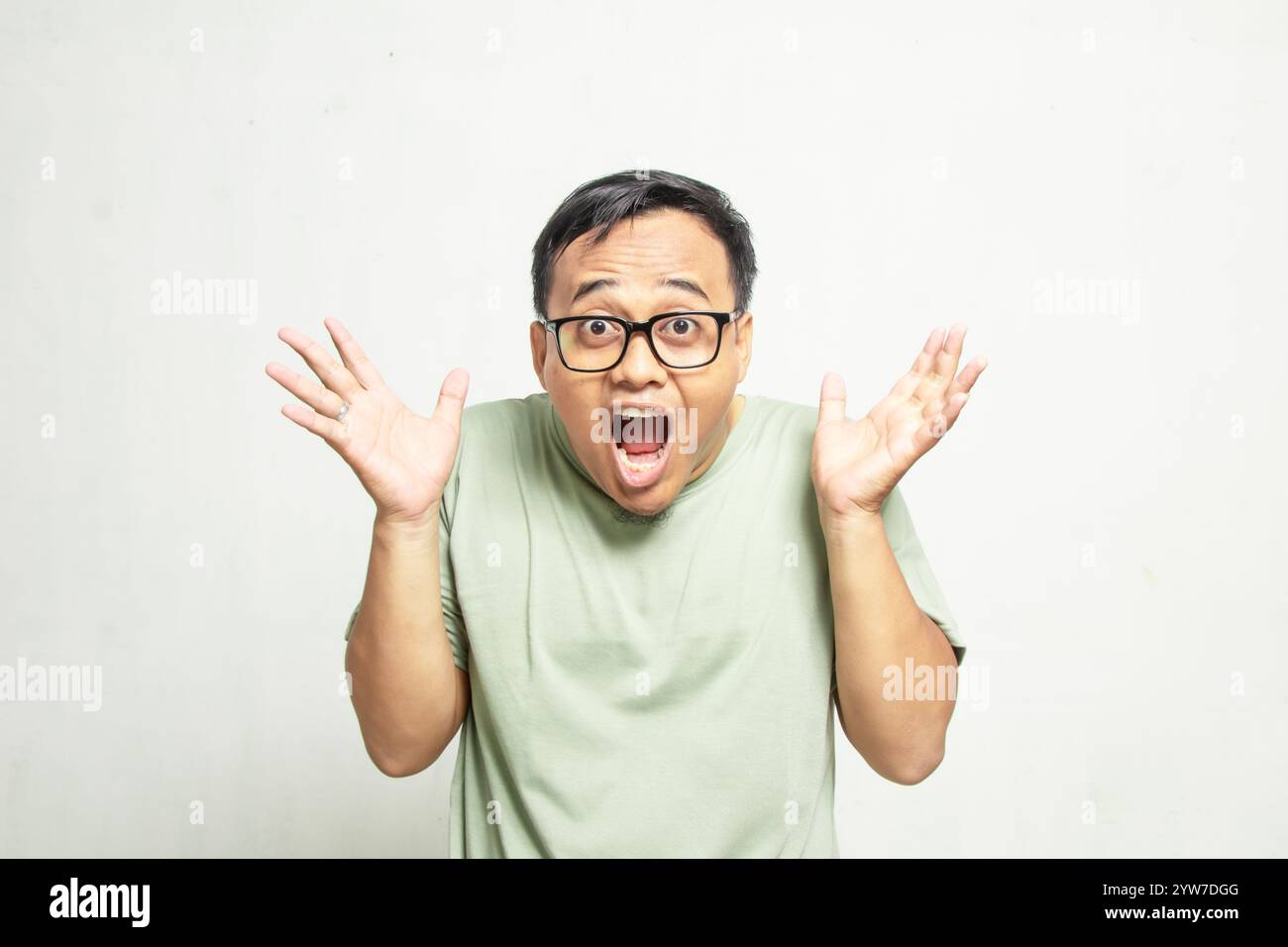 Surprised face of happy Indonesian Asian bespectacled man wearing moss ...