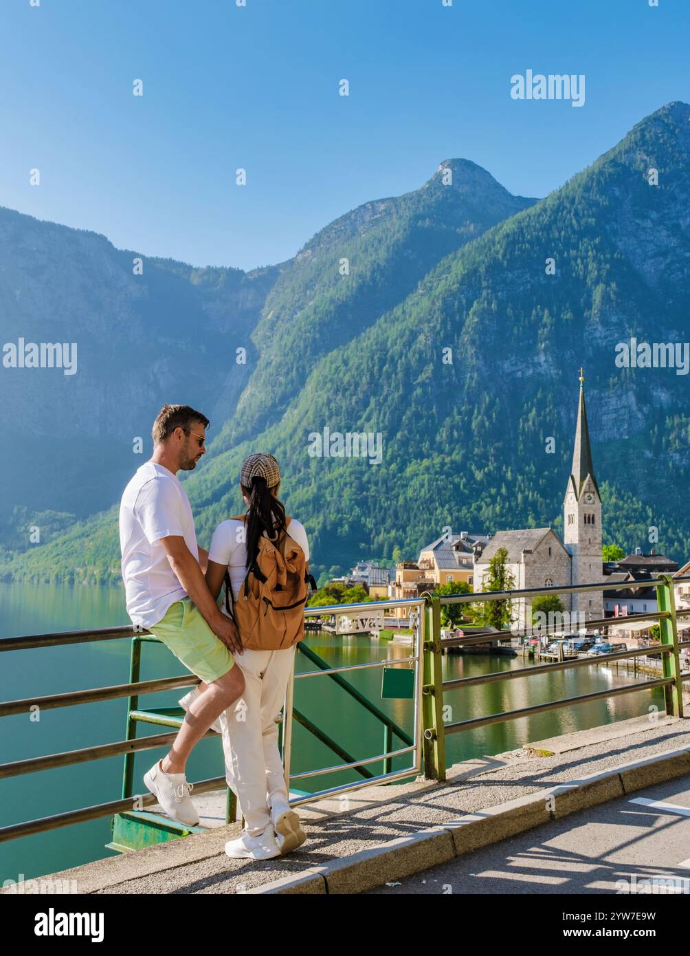 A couple enjoys a beautiful morning by the lake in Hallstatt, Austria ...