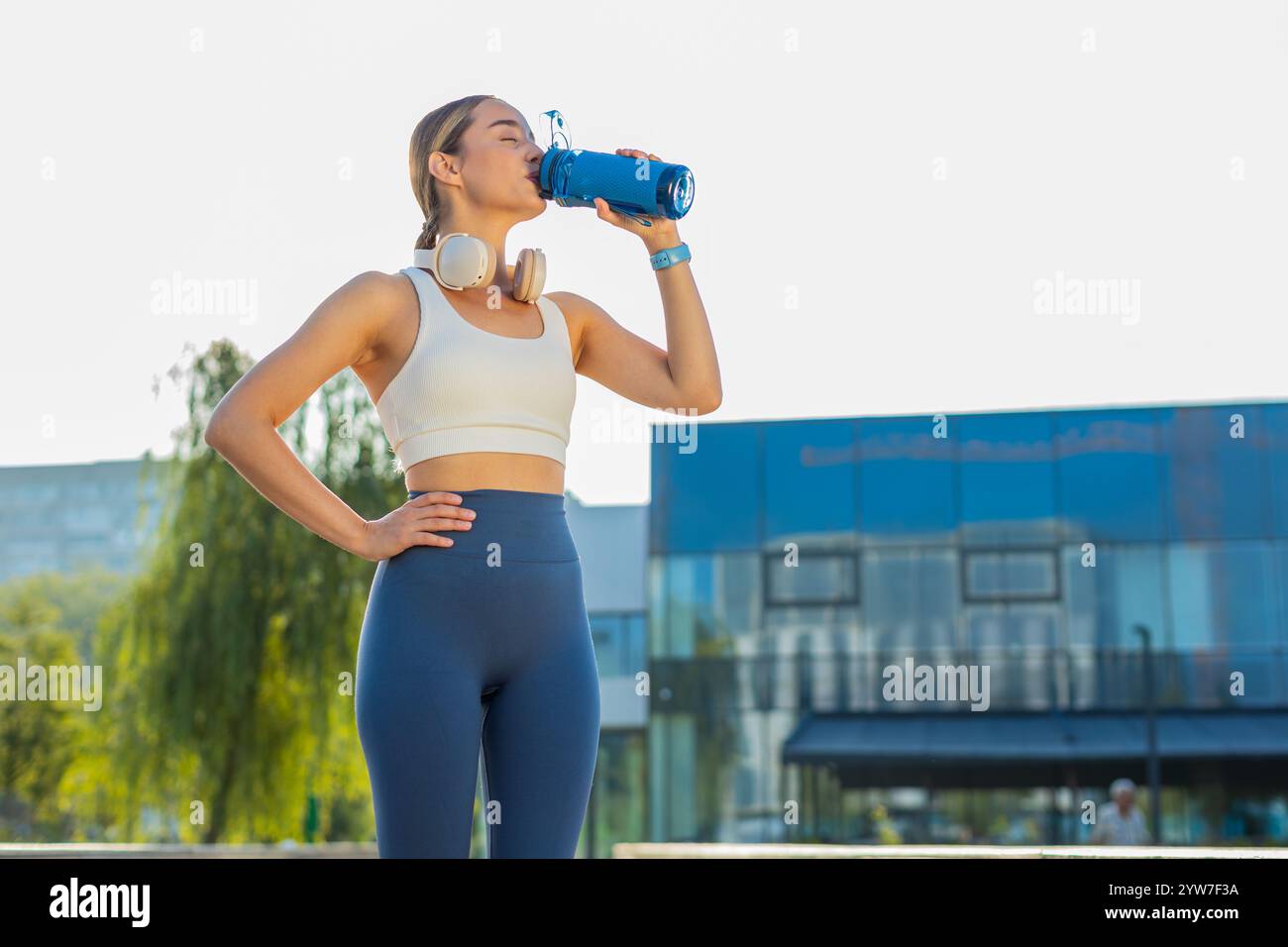 Athletic fit sport runner girl drinking water from bottle after ...