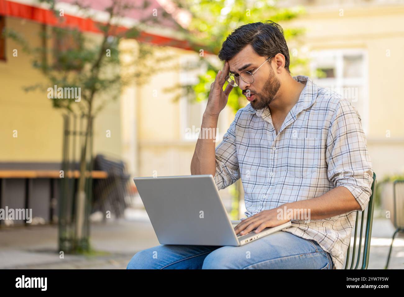 Displeased Indian man using laptop typing browsing working, loses ...