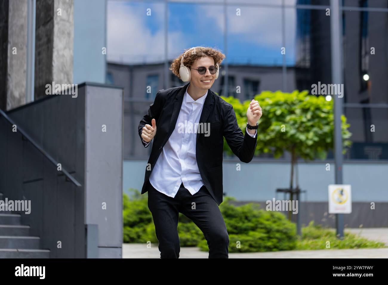 Happy relaxed young Caucasian businessman in wireless headphones ...