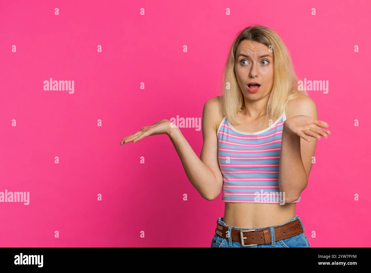 What. Why. Angry confused young woman in crop top raising hands in ...