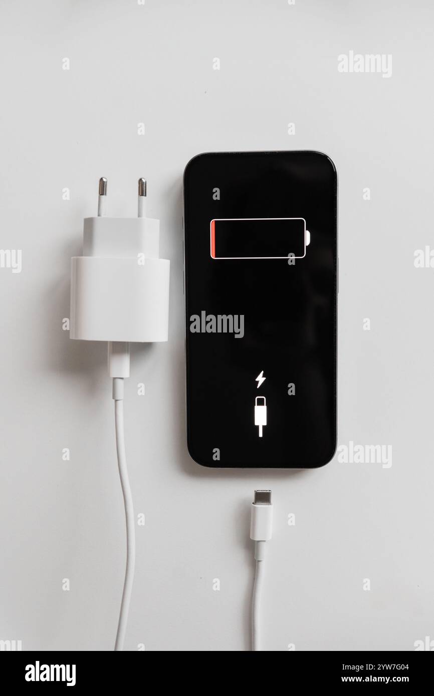 smart phone shows battery low and charger on white background Stock ...
