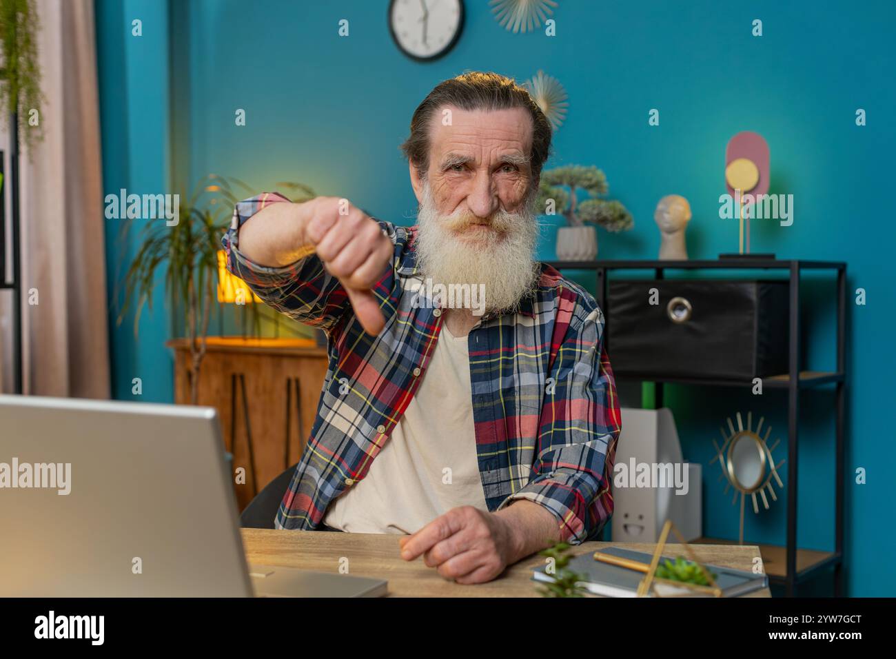 Dislike. Upset senior elderly man working on laptop computer at home ...