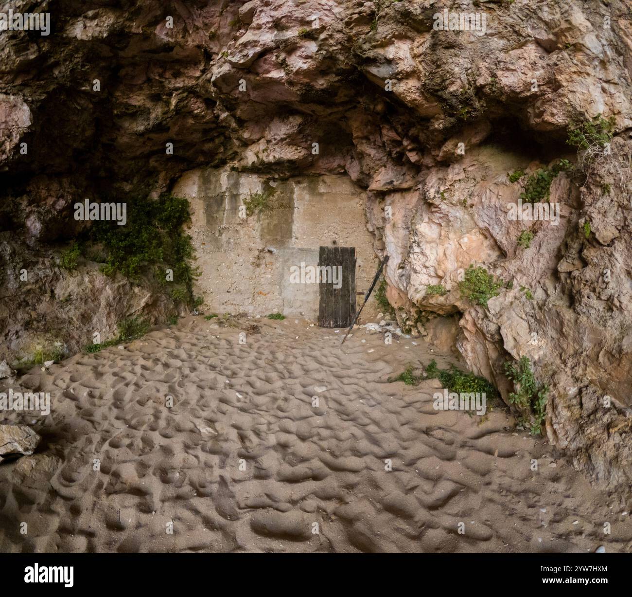 Rustic Wooden Door in Sandy Cave with Natural Rock Walls and Foliage ...