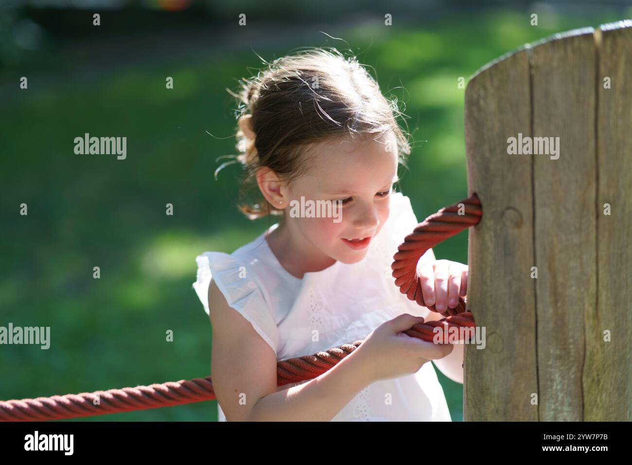 Little cute girl without front tooth rope playground summer park ...