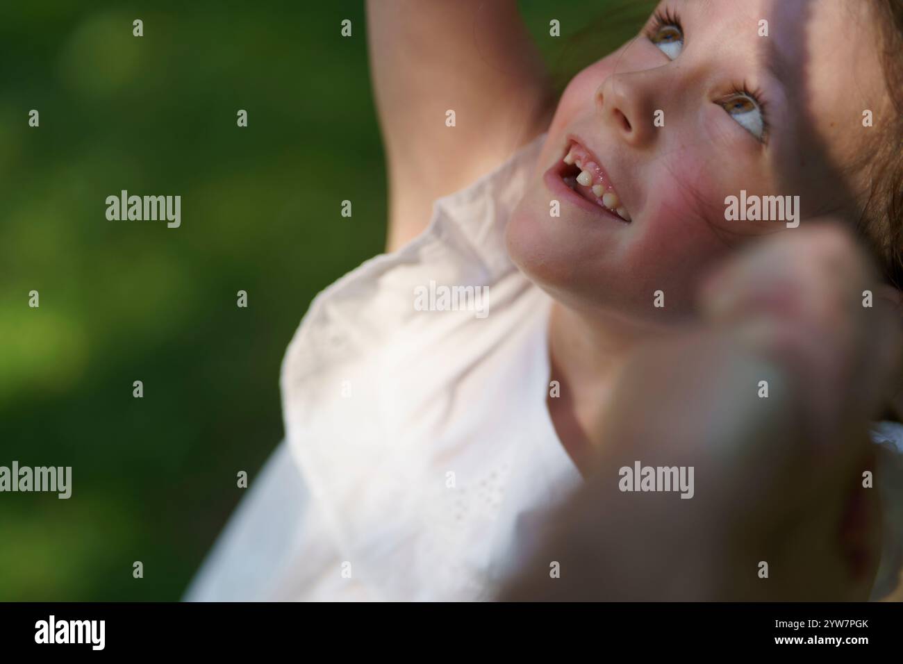 Little cute girl without front tooth in park in summer close-up ...