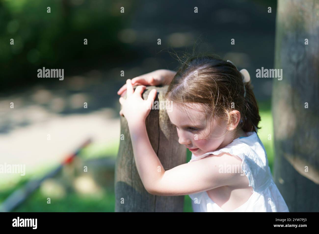 Little cute girl without front tooth rope playground summer park ...