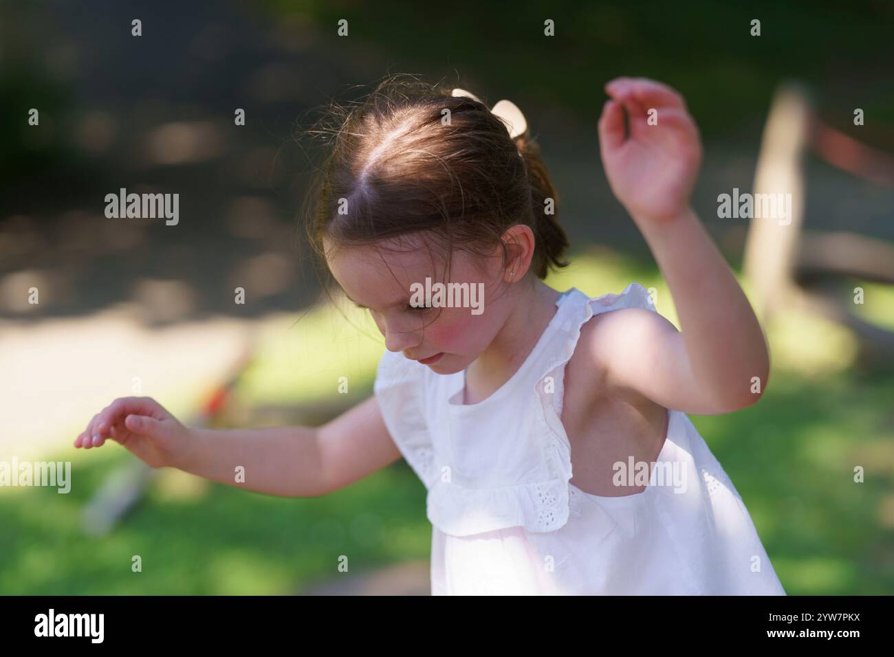 Little cute girl without front tooth rope playground summer park ...