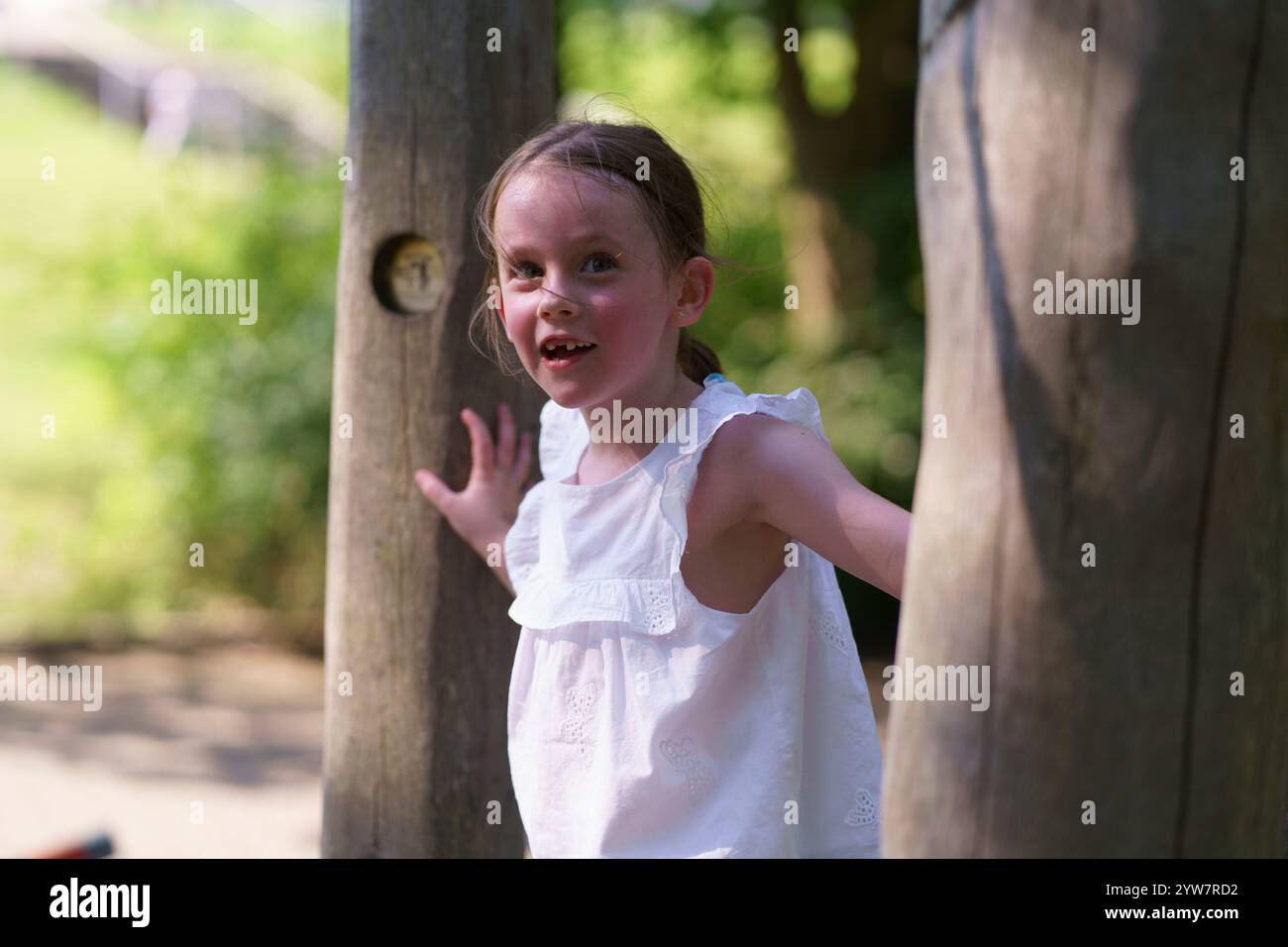 Little cute girl without front tooth rope playground summer park ...