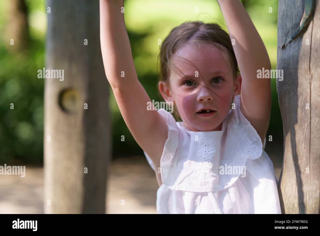 Little cute girl without front tooth rope playground summer park ...