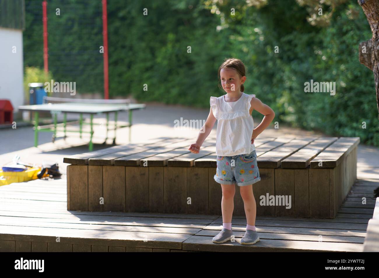Little cute girl without front teeth on playground in summer in park ...