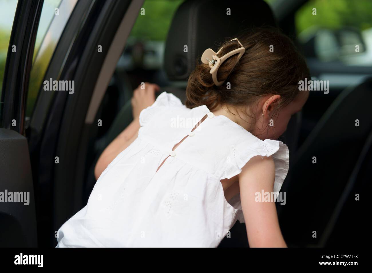 Little girl gets into car in parking lot opening door. Healthy active ...