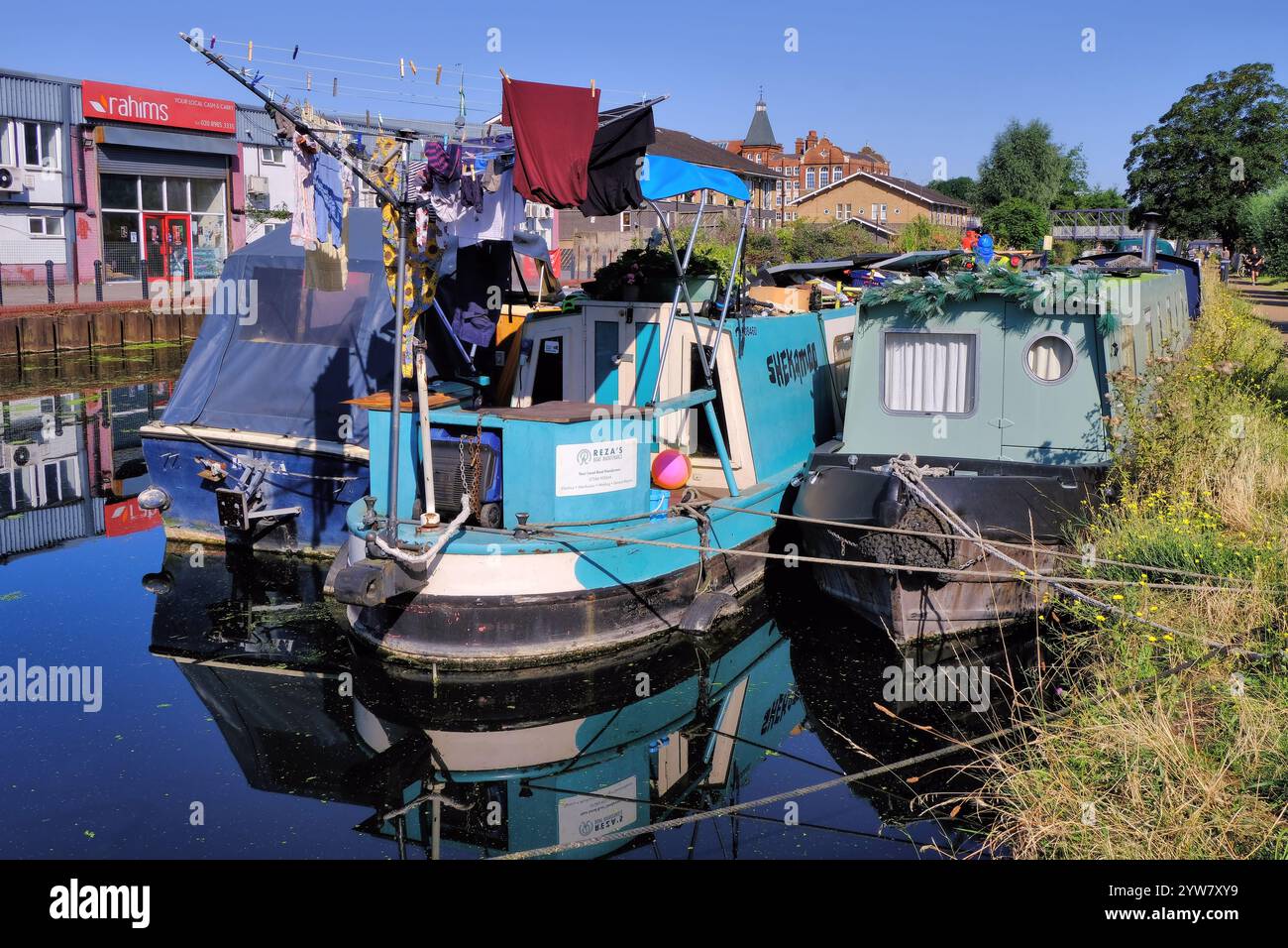 Colourful canal boats, barges, with rotary clothes line and mirror ...