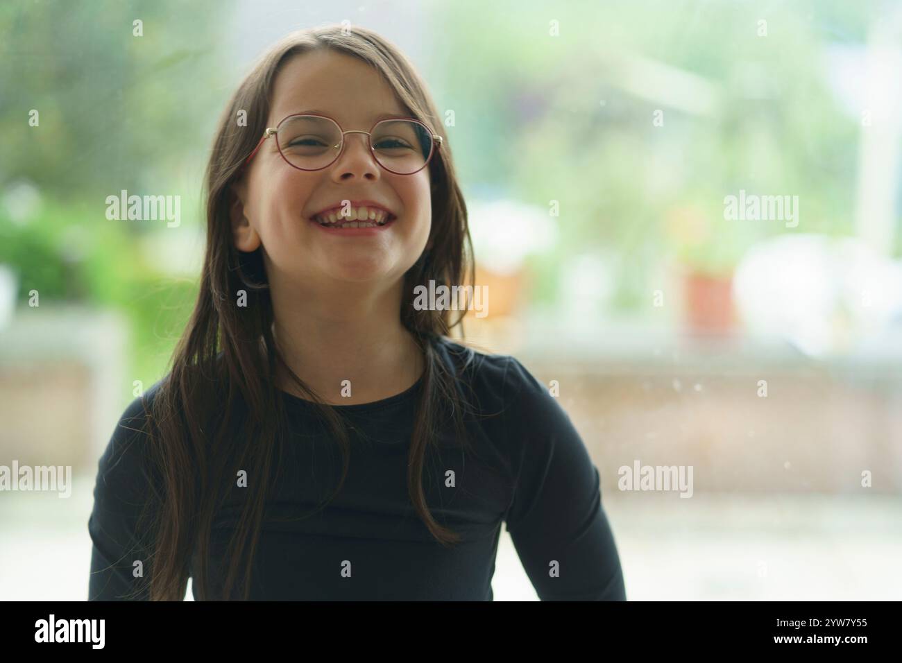 Little cute smiling girl with all her teeth in front of a big ...