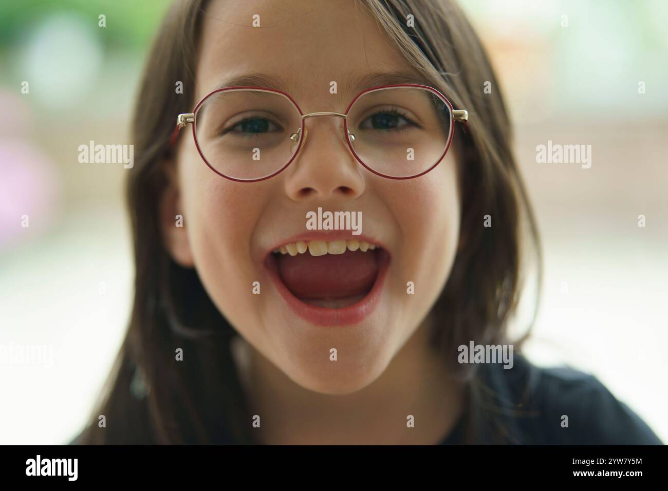 Little cute smiling girl with all her teeth in front of a big ...