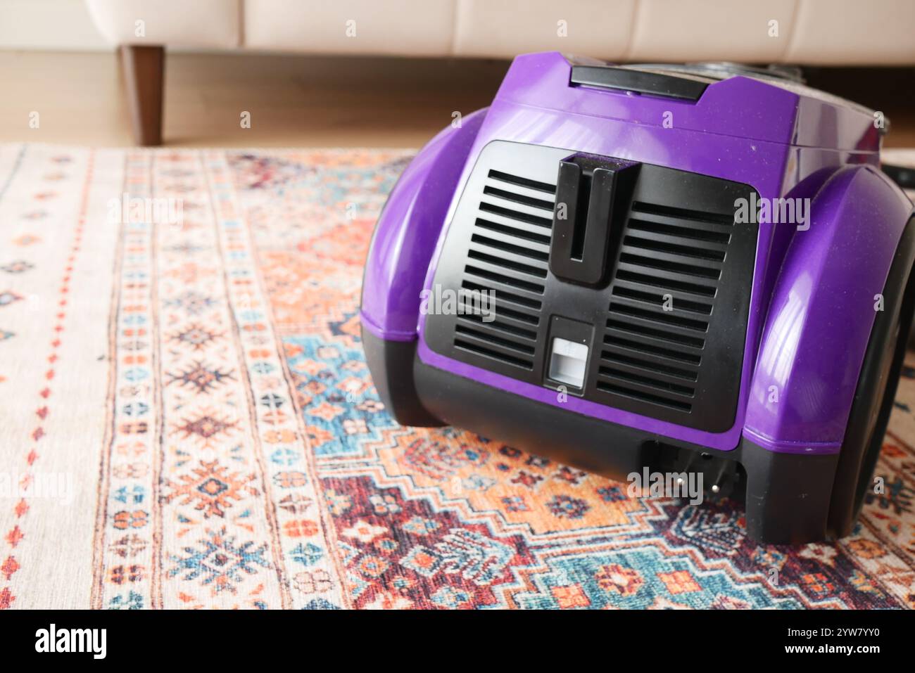 A purple vacuum cleaner placed on a beautifully designed vintage carpet ...