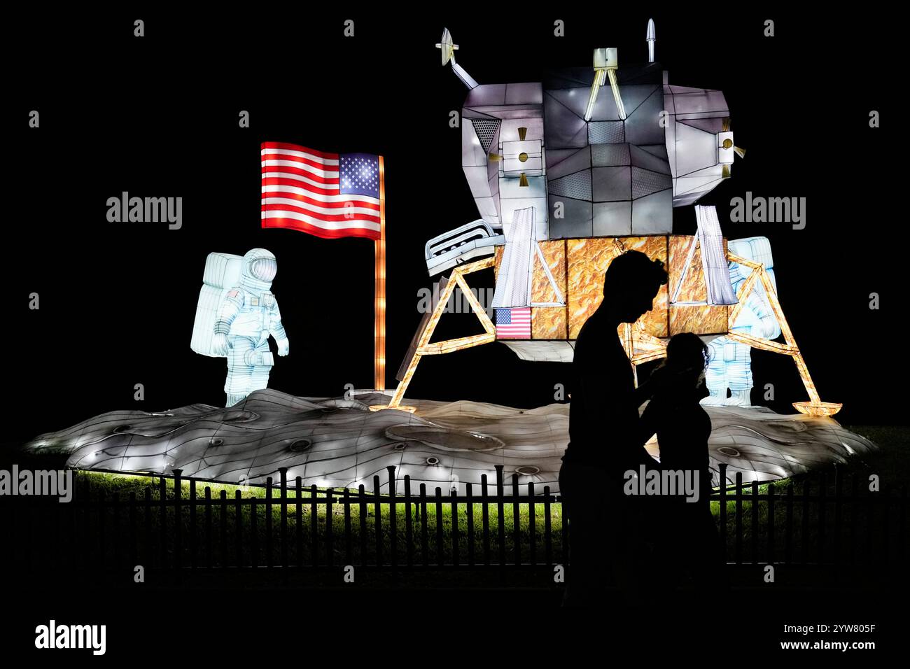 People walk among space-themed holiday lights at Space Center Houston ...