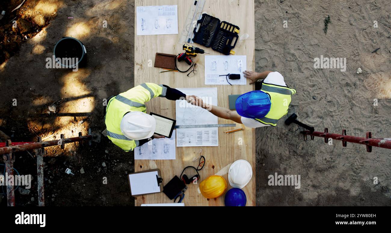Blueprint, construction and men at table with handshake, collaboration ...